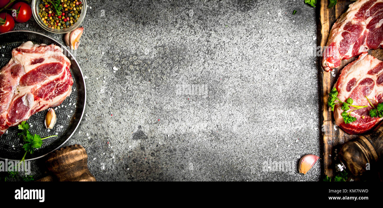 Raw meat background. Raw steak with herbs and spices on the old Board ...