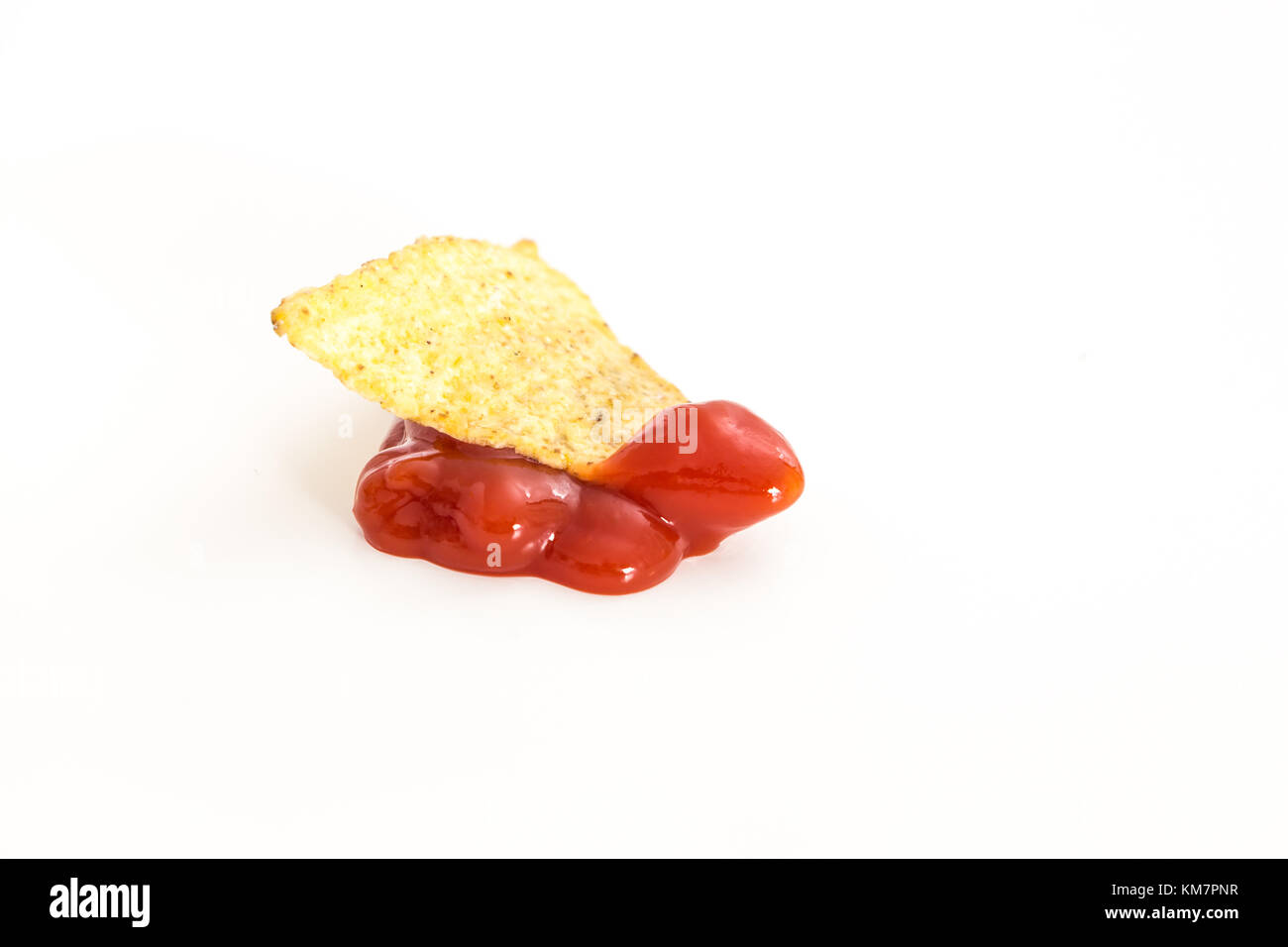 Crispy nacho chip in salsa, on white background Stock Photo - Alamy