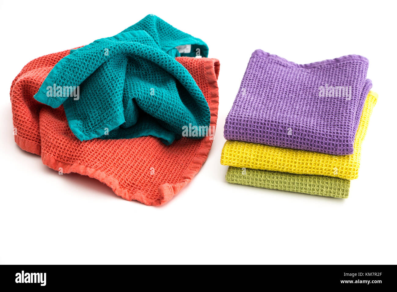 Pile of messy and stack of folded colorful kitchen towels, on white ...