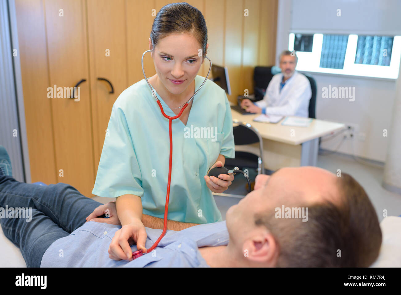 female doctor checking on patient heart rate Stock Photo - Alamy