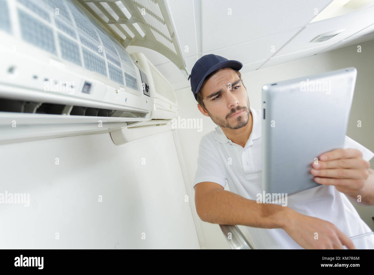 young contractor working carefully and seriously at clients office ...