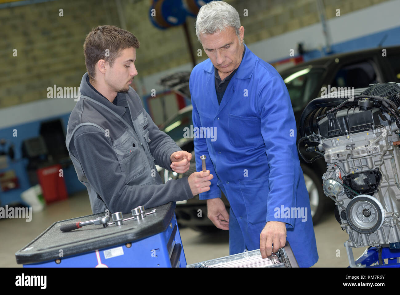 mechanic helping apprentice to fix engine Stock Photo - Alamy