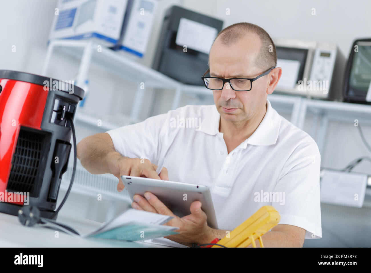 man looks guides in internet while repairing a device Stock Photo - Alamy