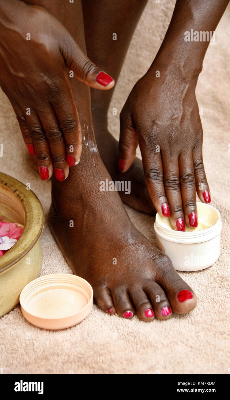 African woman rubbing cream on herself Stock Photo - Alamy
