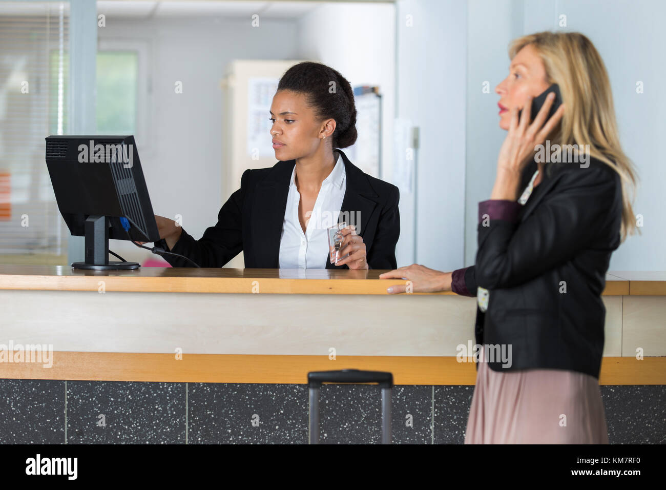 customer on telephone at hotel reception Stock Photo - Alamy