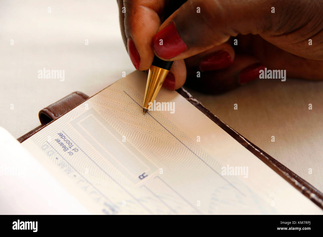 African woman signing a cheque Stock Photo - Alamy