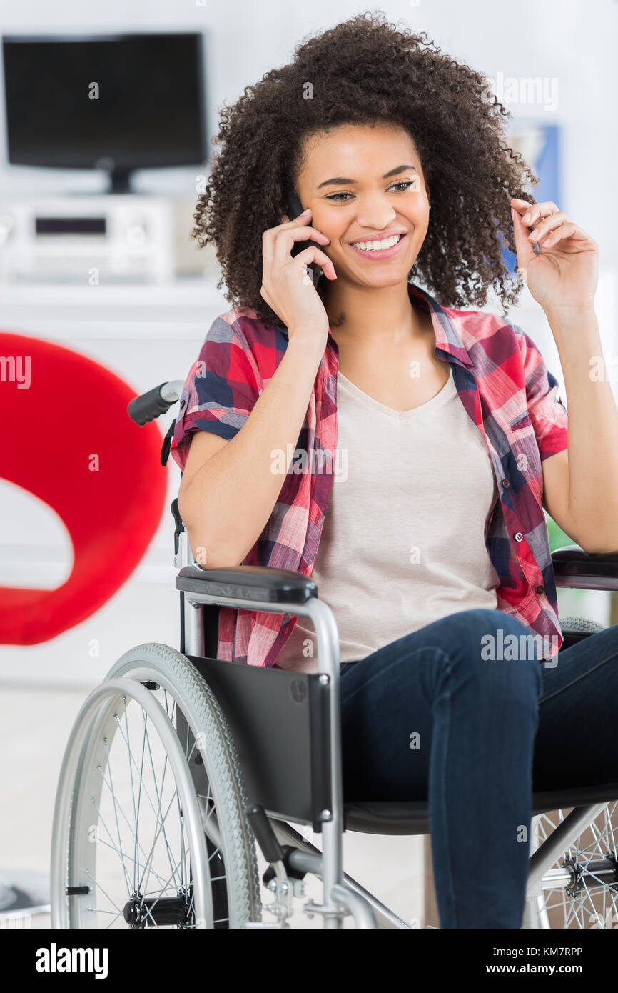 disabled woman in wheelchair using mobile phone at home Stock Photo - Alamy