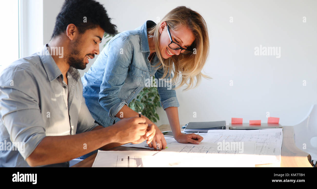 Coworkers working on project together in office Stock Photo - Alamy