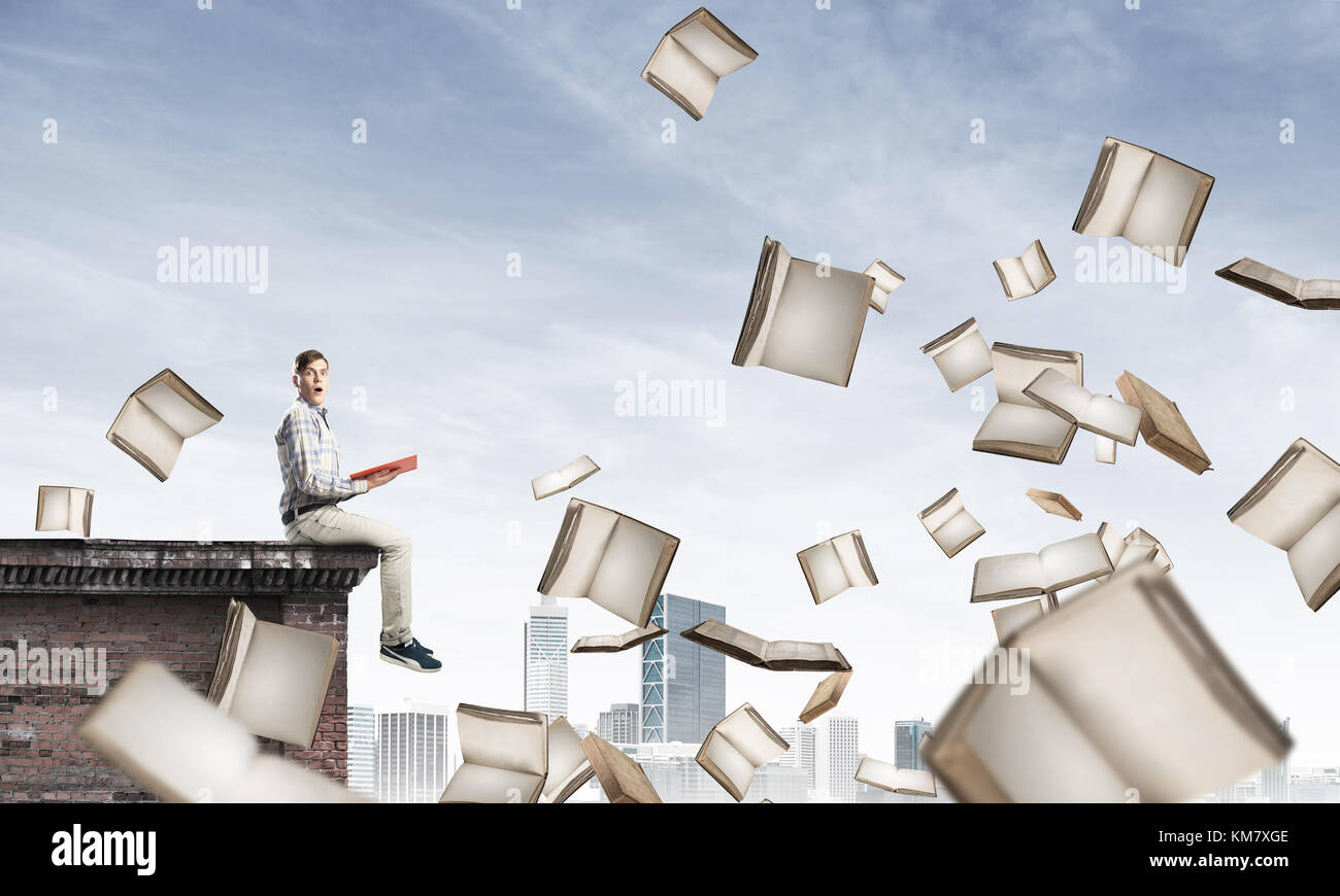 Man reading book and many of them flying in air Stock Photo - Alamy