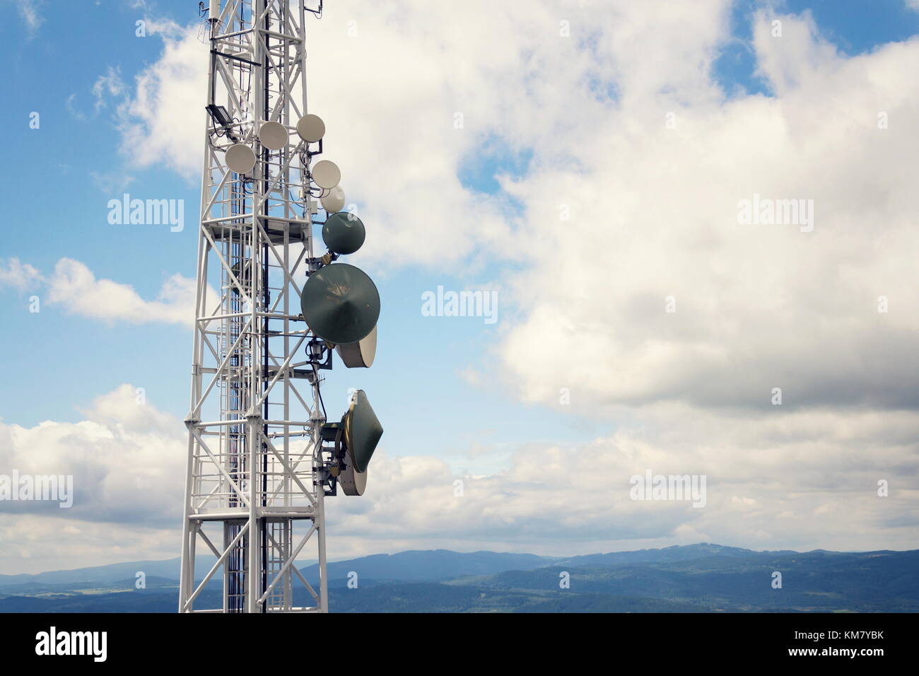 Aerials and transmitters on telecommunication tower with mountains in background Stock Photo - Alamy