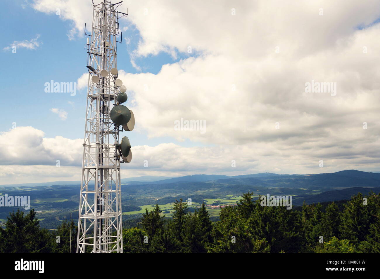 Aerials and transmitters on telecommunication tower with mountains in ...