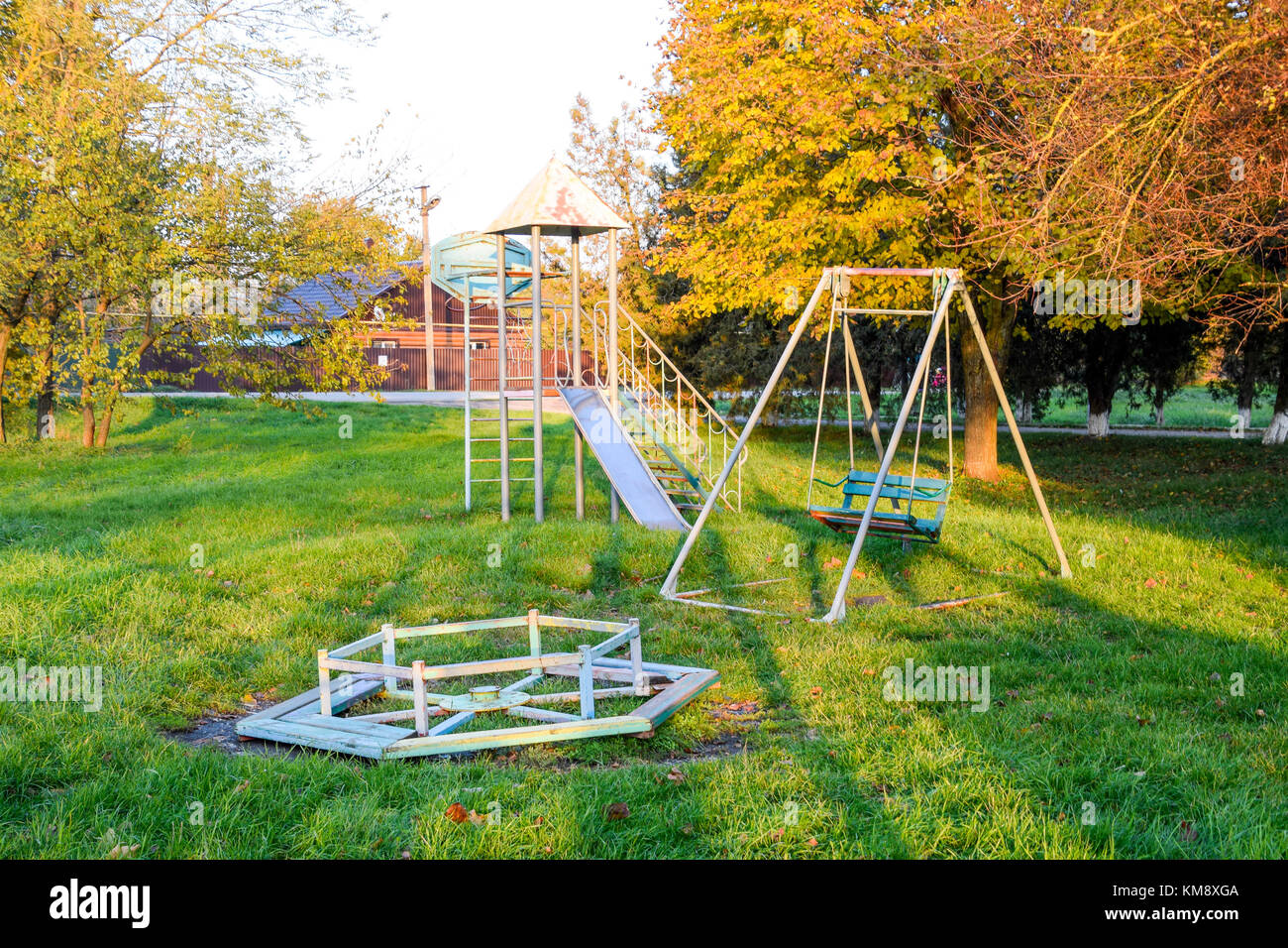 Carousel, swing and slide. Children playground. Swings and a slide to ...