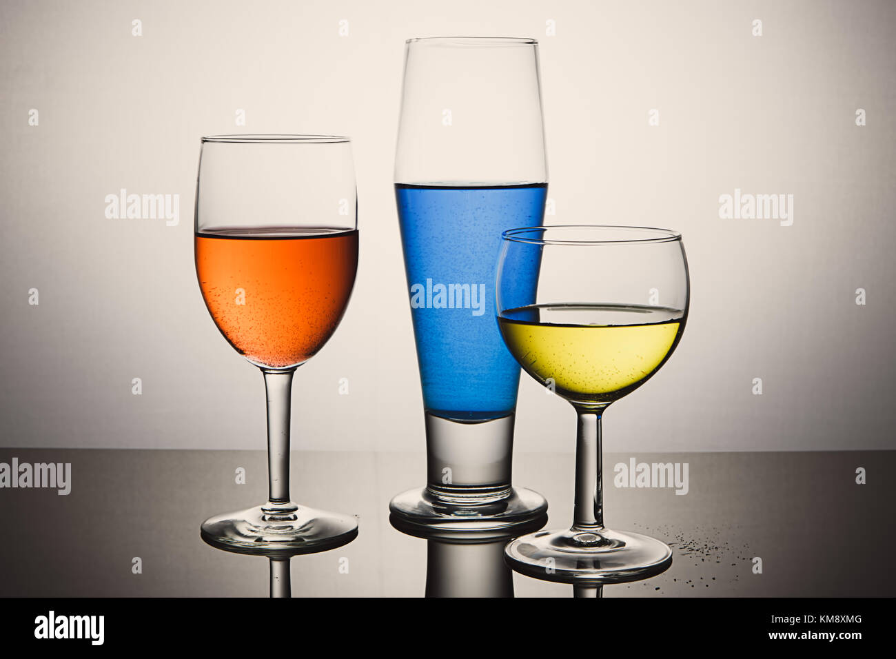 Various glasses that are filled with colored liquid for an abstract ...