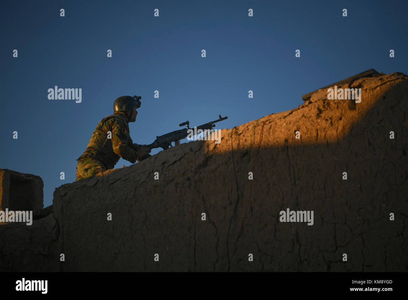 an afghan special operator emplaces his m240 machine gun into a support ...