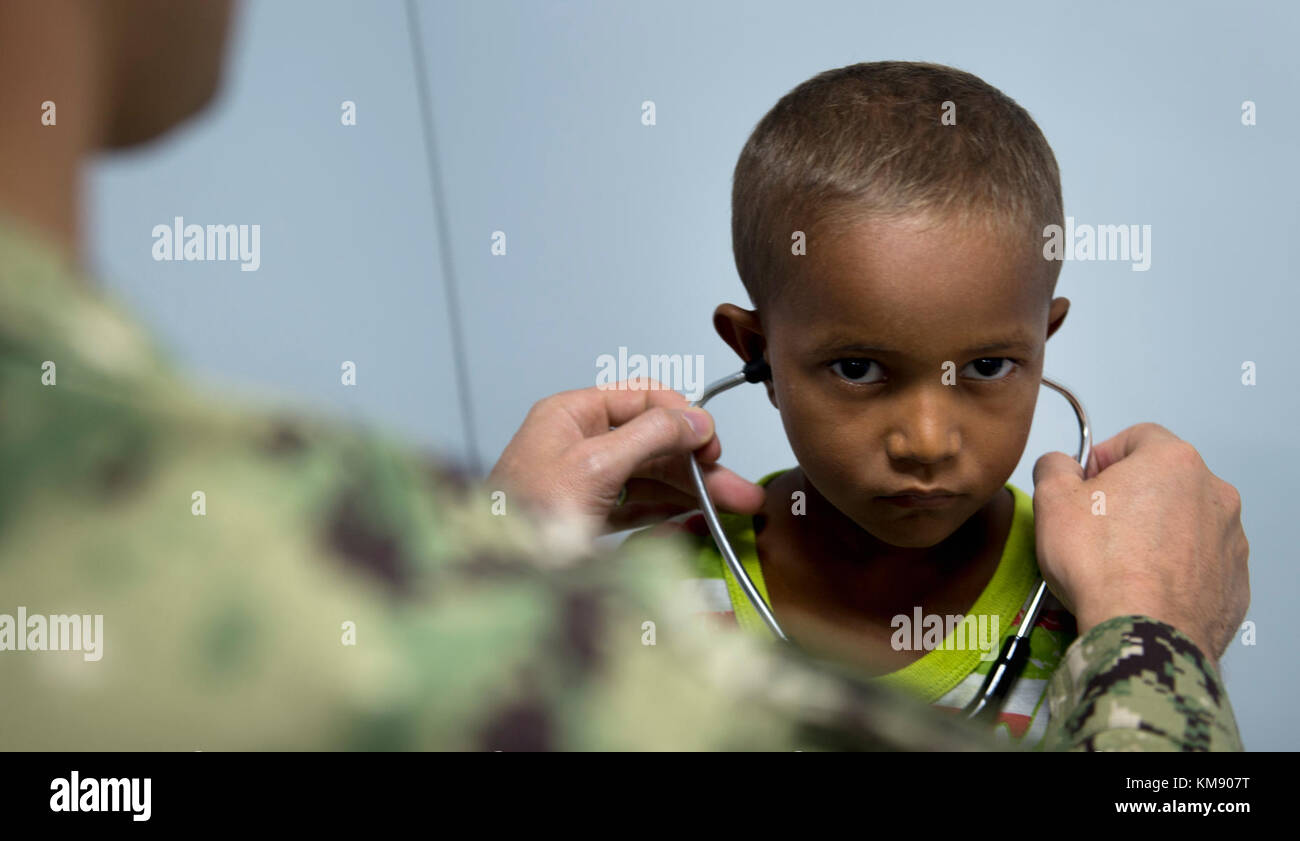 Lt. Gregory Condos, a U.S. Navy doctor, lets a young boy from the ...