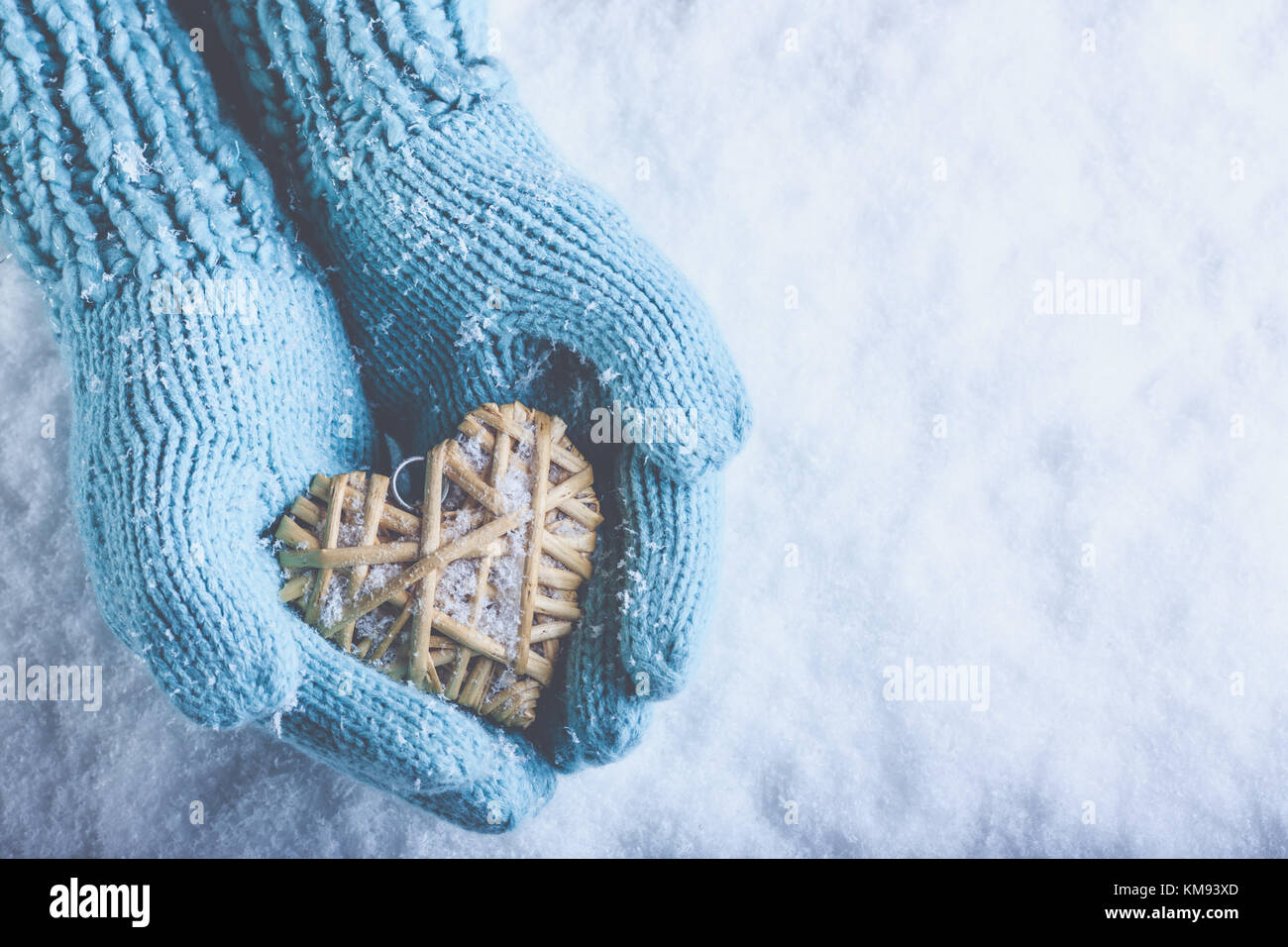 Female hands in light teal knitted mittens with entwined beige flaxen ...