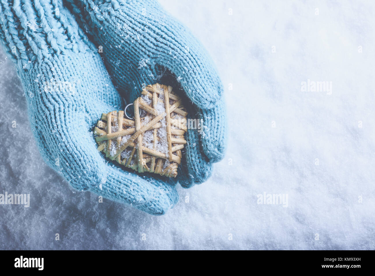 Female hands in light teal knitted mittens with entwined beige flaxen ...