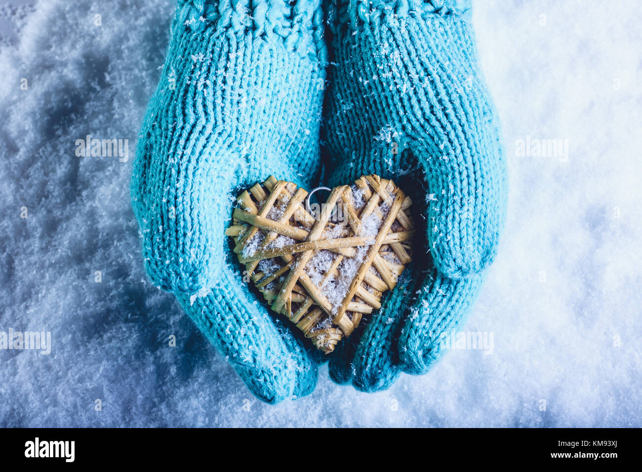 Female hands in light teal knitted mittens with entwined beige flaxen ...