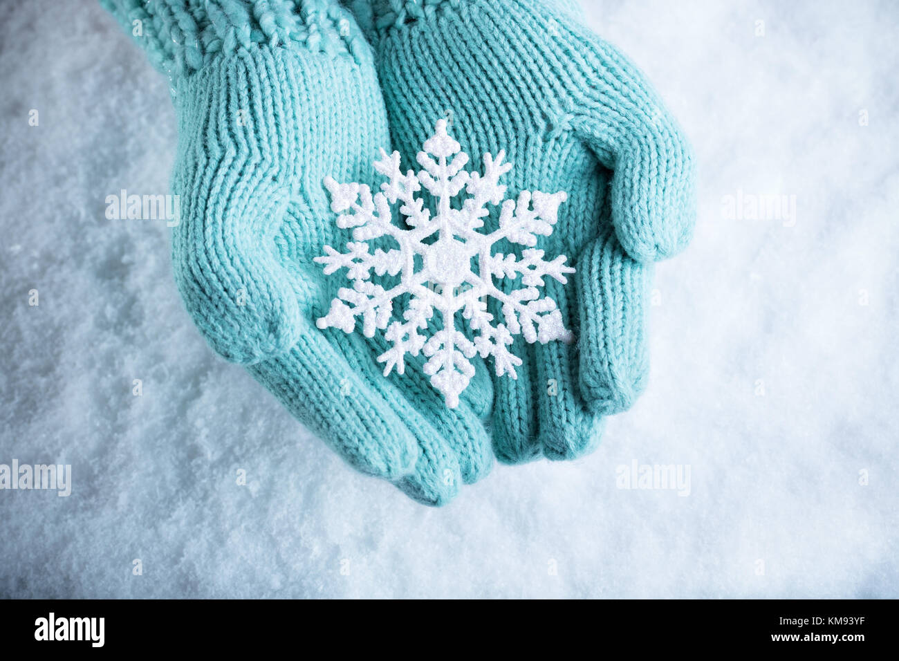 Female hands in light teal knitted mittens with sparkling wonderful ...