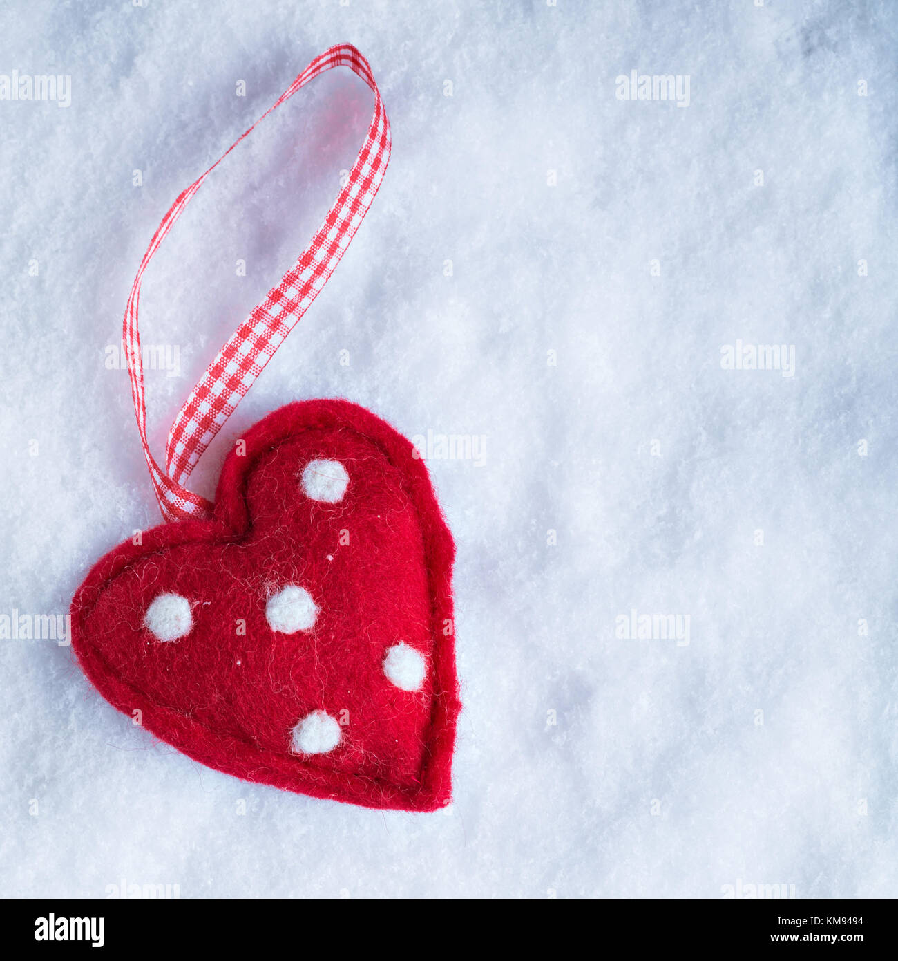 Red toy suave heart on a frosty white snow winter background. Love and ...