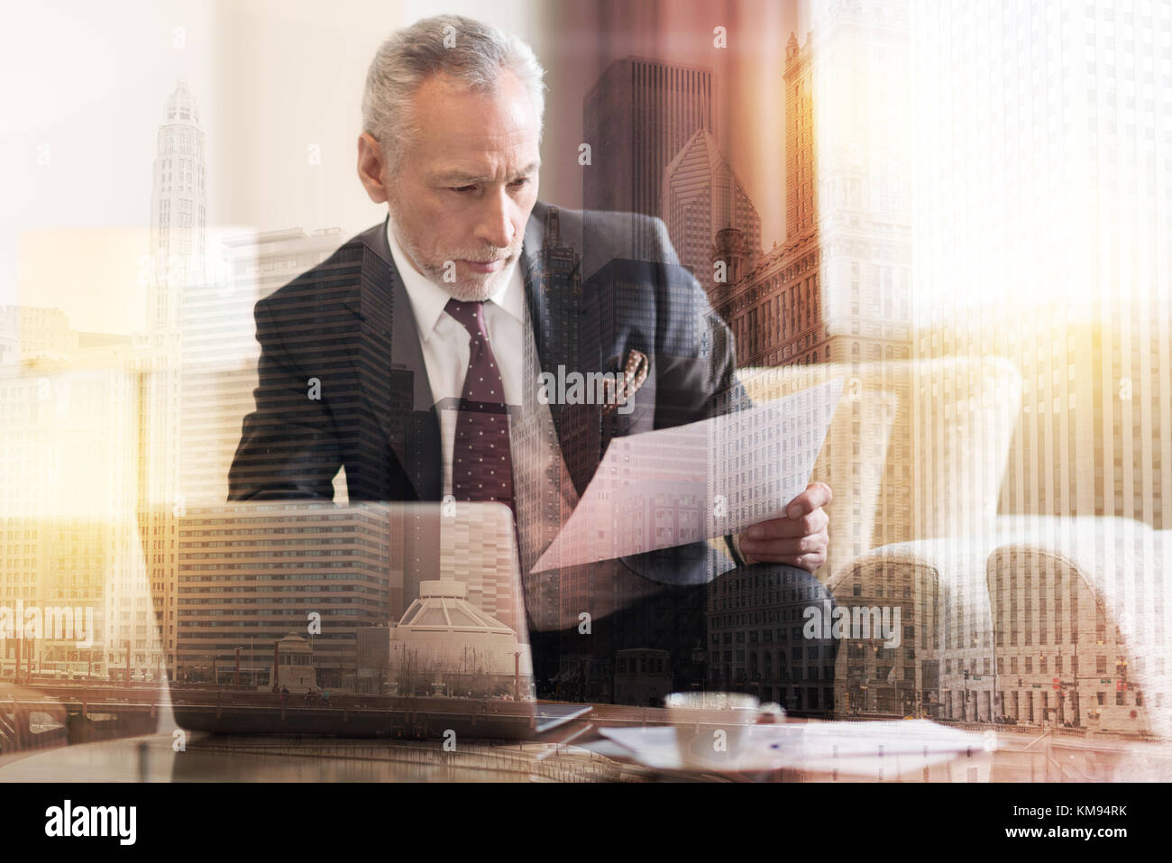 Serious entrepreneur reading business document Stock Photo - Alamy