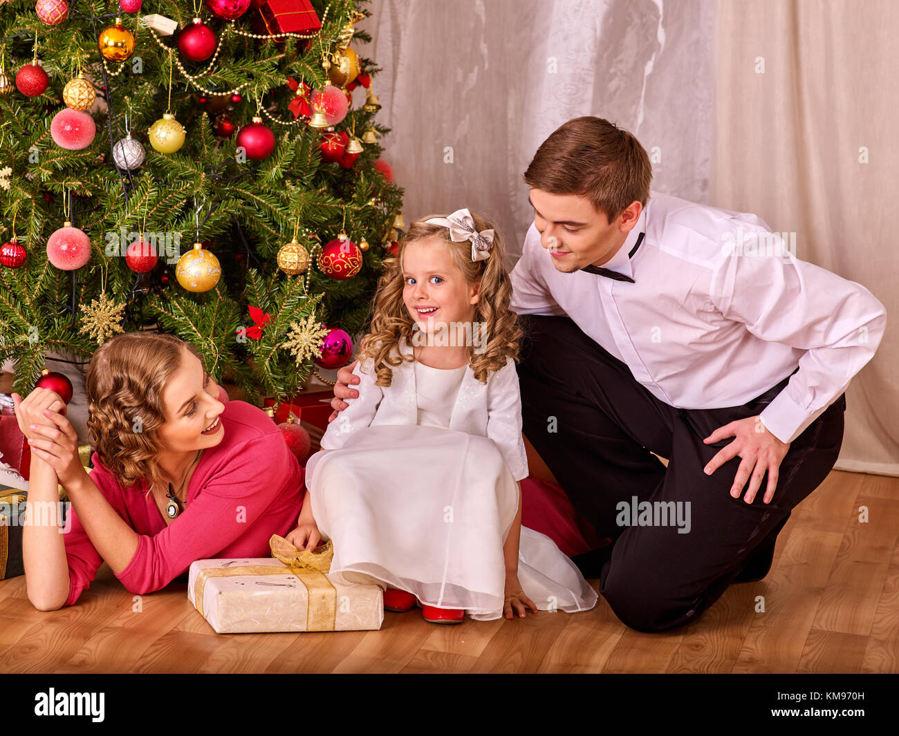 Family with children dressing Christmas tree Stock Photo - Alamy