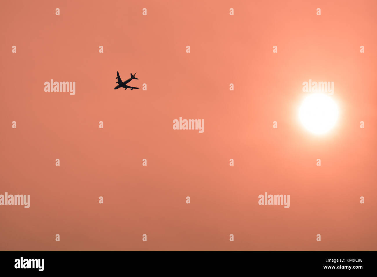 A jet plane flies into the orange sunset Stock Photo - Alamy