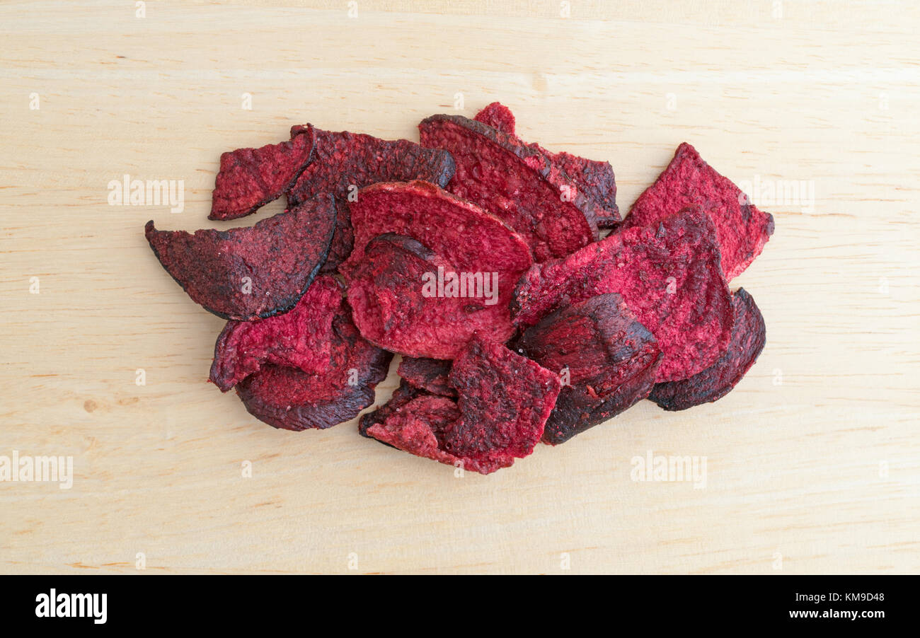 Top view of a small portion of salted red beet chips atop a wood ...