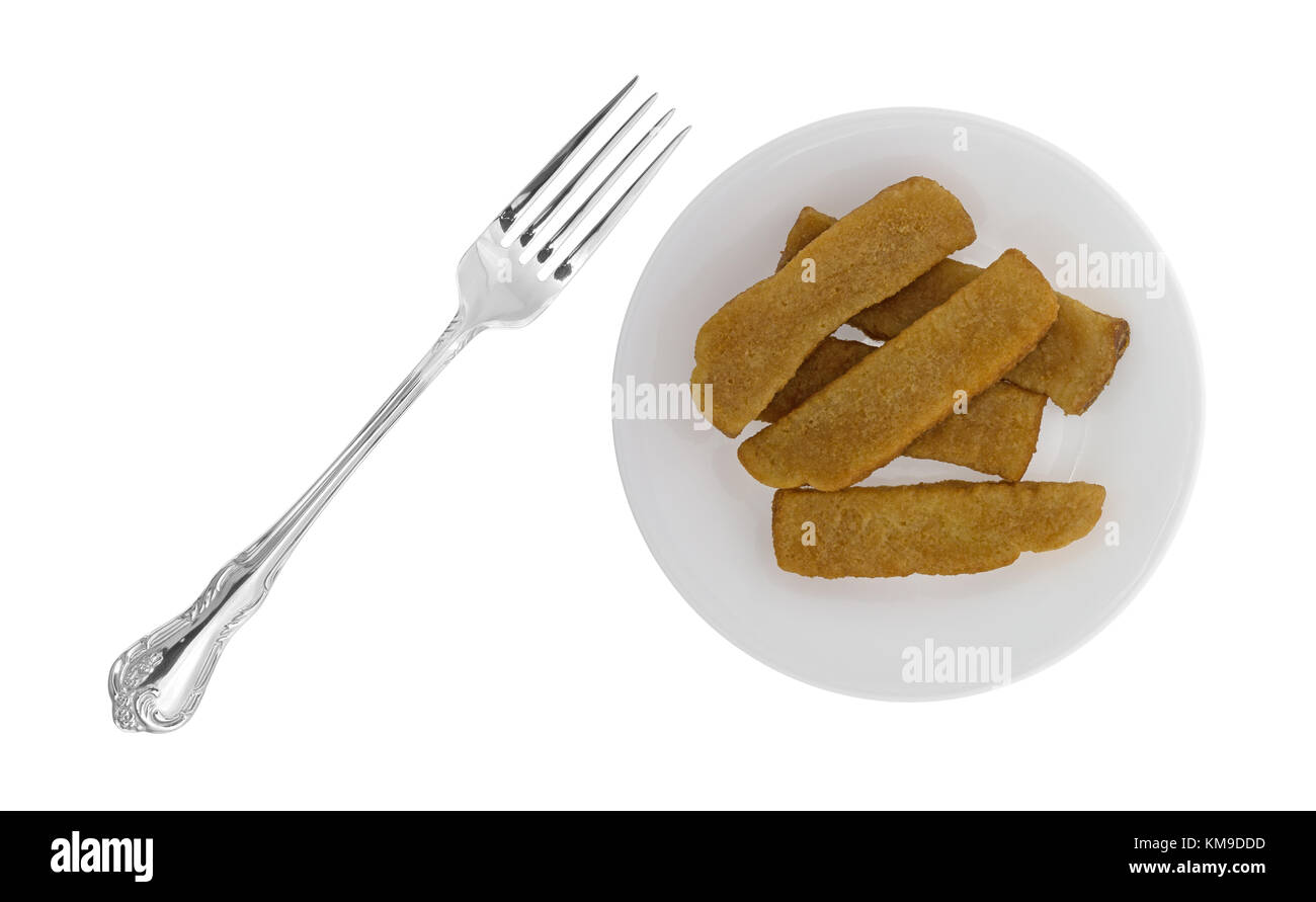 Top view of a serving of French toast sticks on a plate with a fork to ...