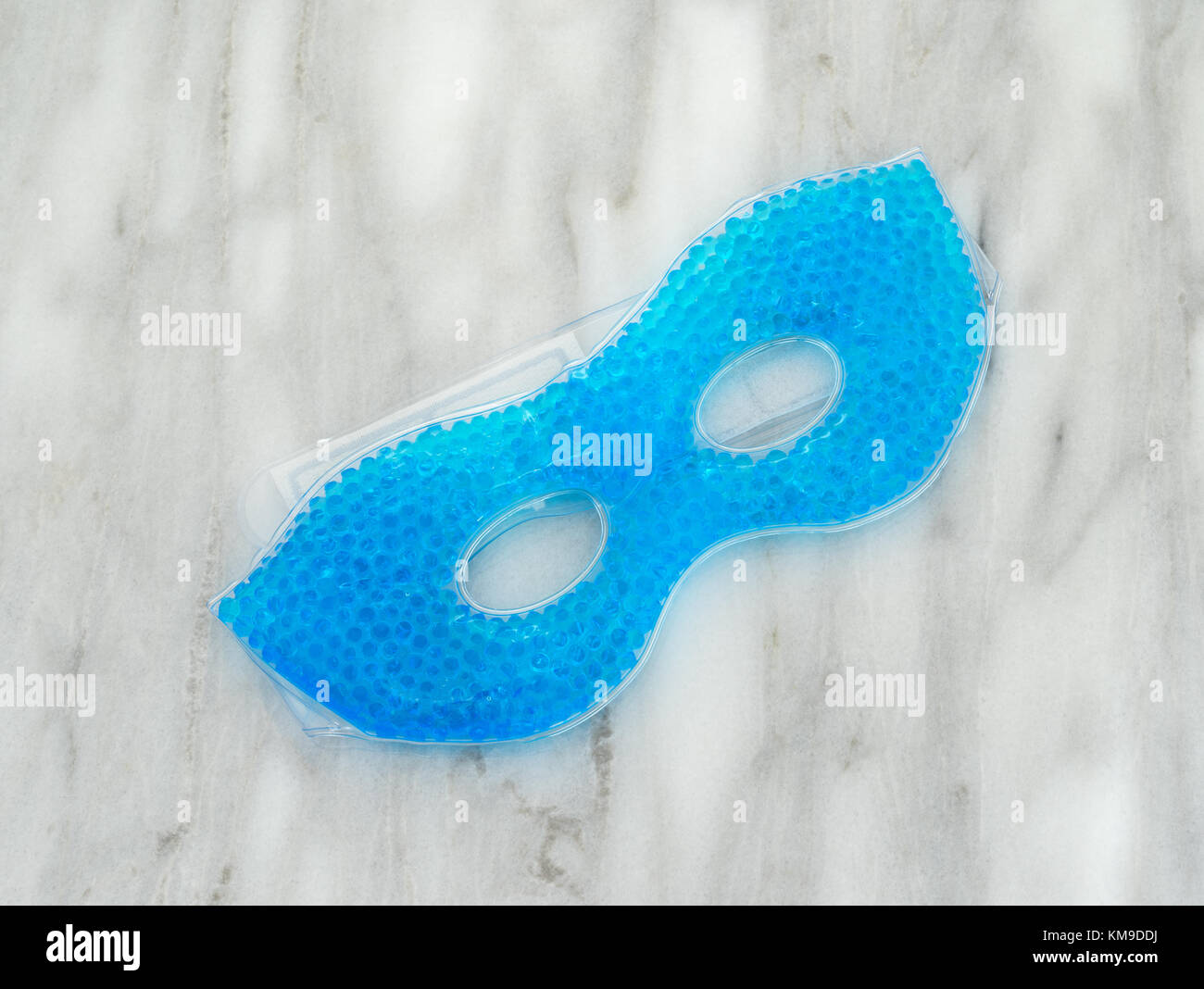 A blue beaded gel eye mask at an angle atop a marble counter top Stock ...