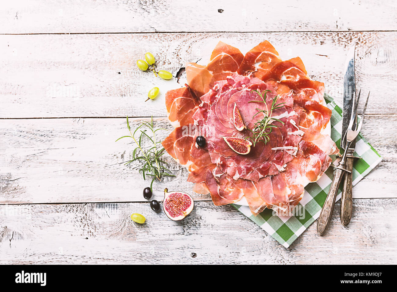Sliced jamon on white plate. Parma ham, hamon on wooden background with ...