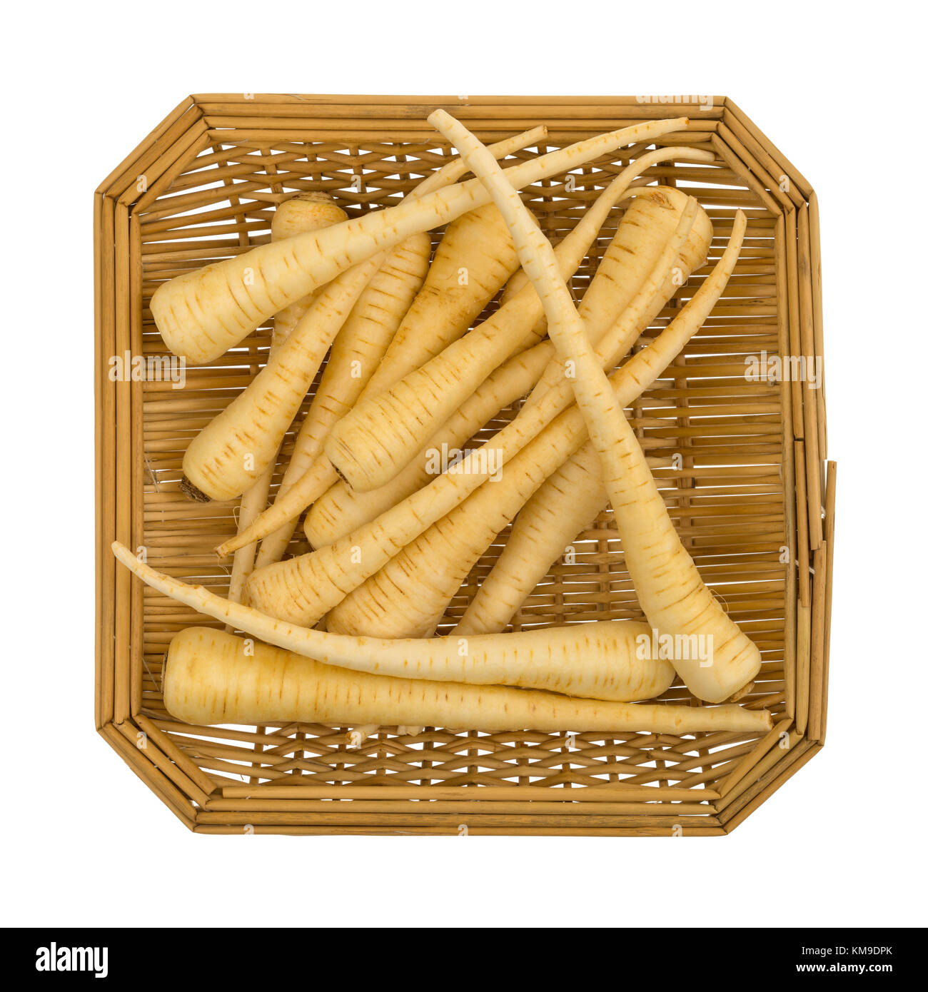 Top view of a small wood basket filled with whole parsnips isolated on ...