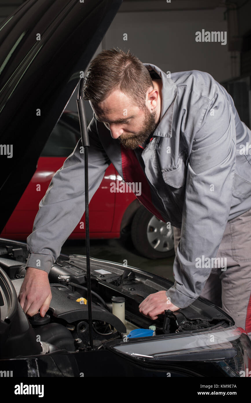 Mechanic checking the oil cap in a car engine Stock Photo - Alamy