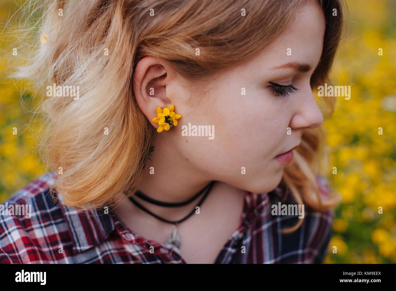Portrait of a woman with a flower in her ear Stock Photo - Alamy