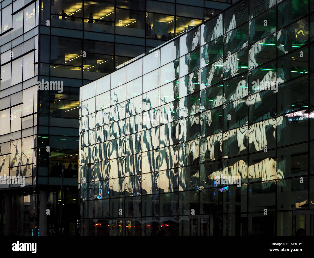 distorted reflections of the evening cityscape in new glazed buildings ...