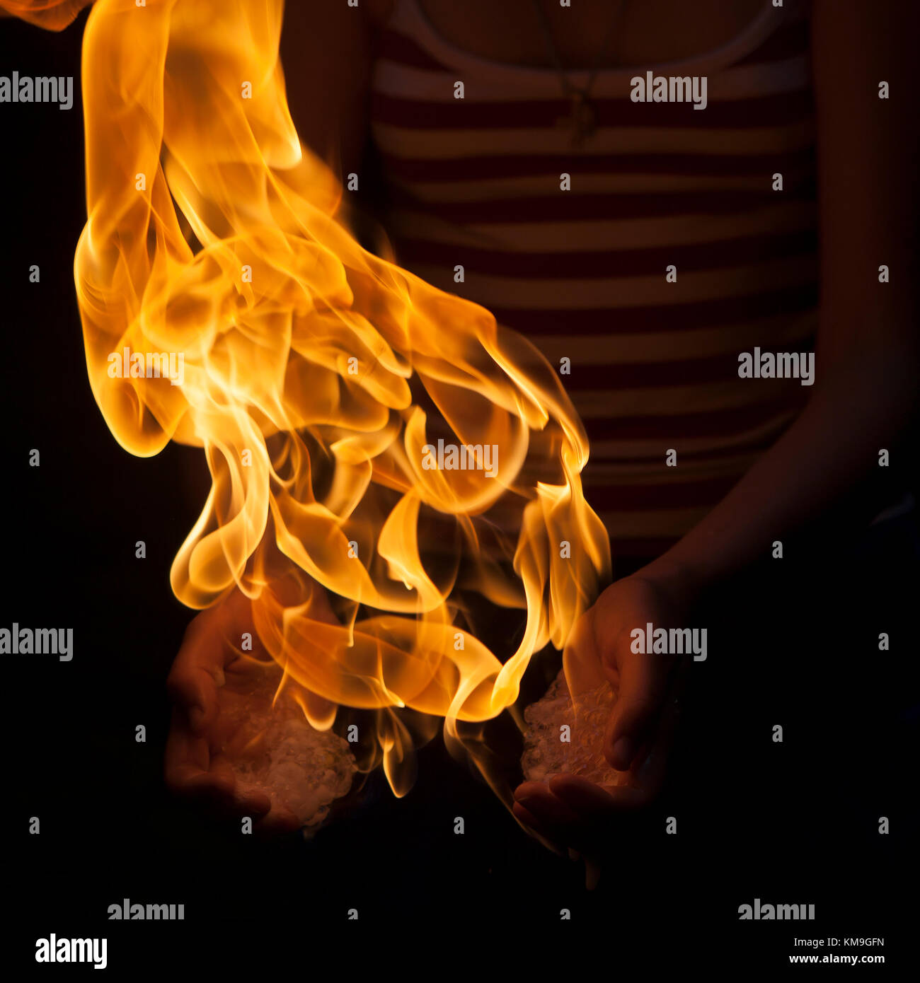 a fire burning in the palm of a magician, against a dark background ...