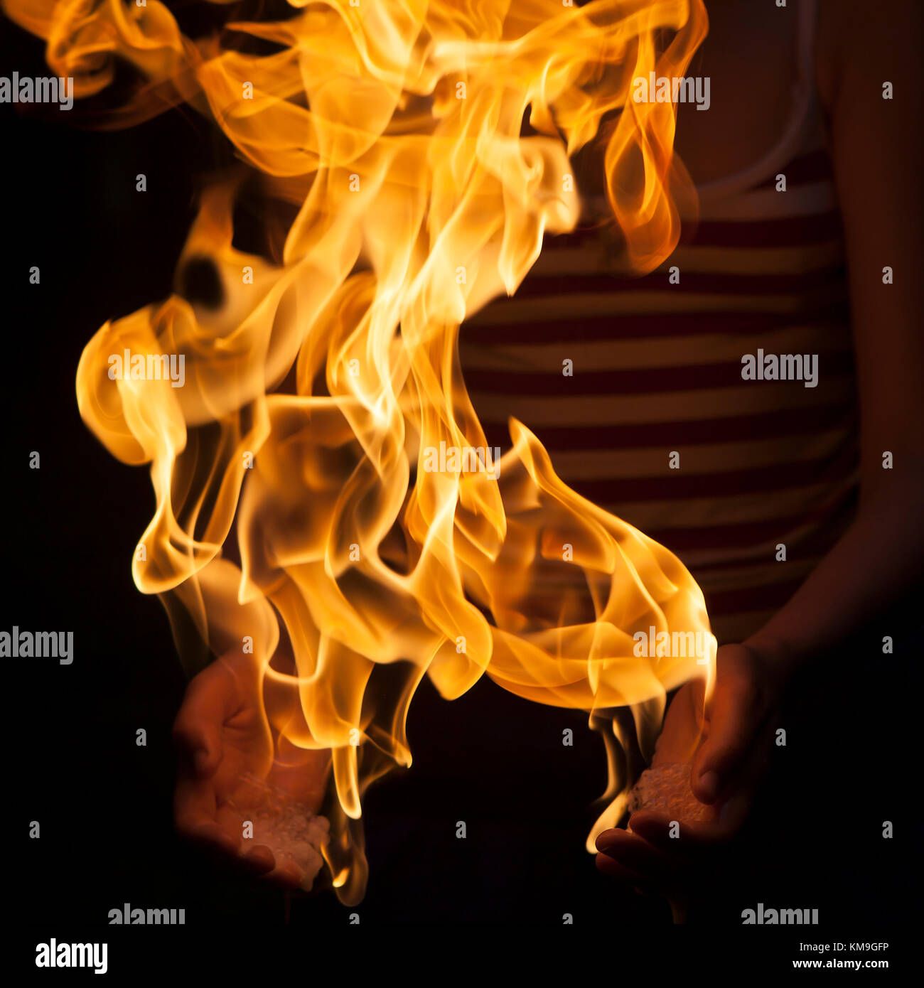 a fire burning in the palm of a magician, against a dark background ...