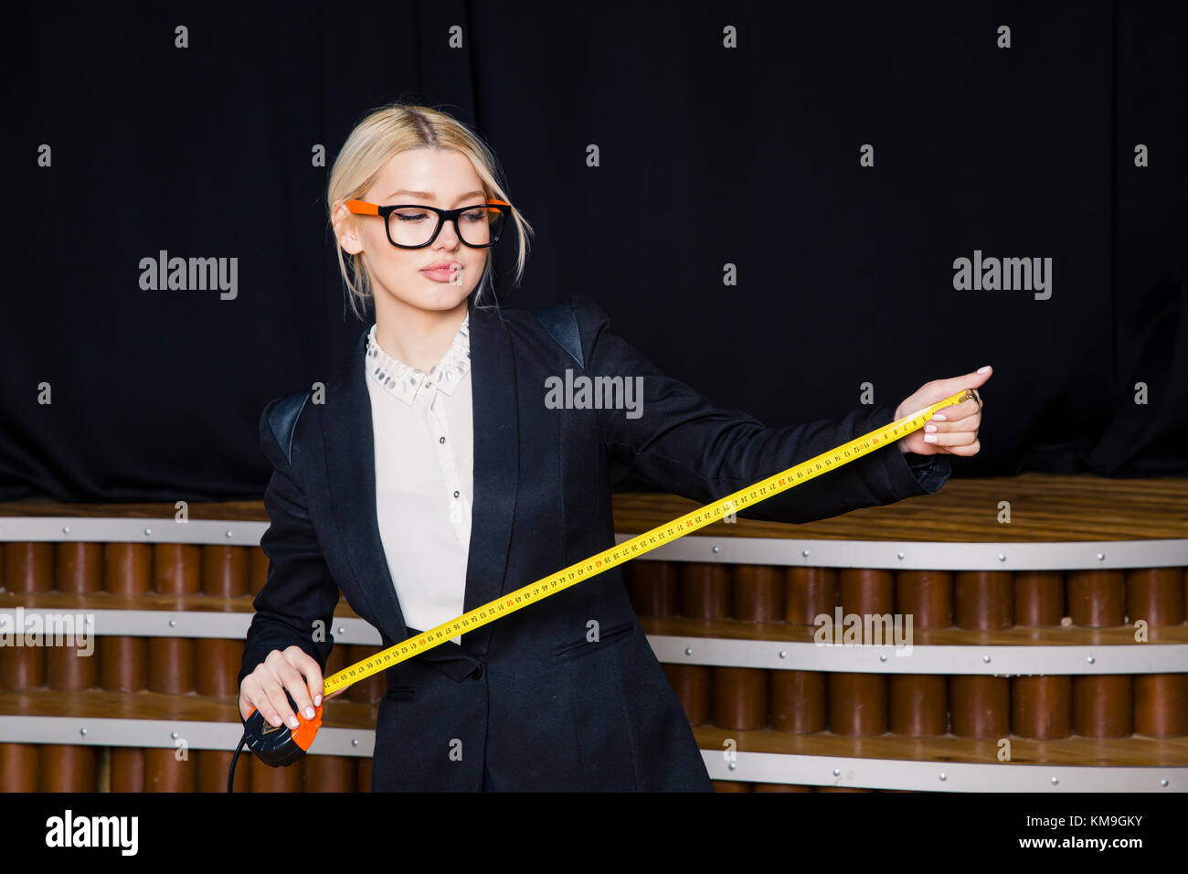Beautiful blonde businesswoman with tape measure at loft office in ...