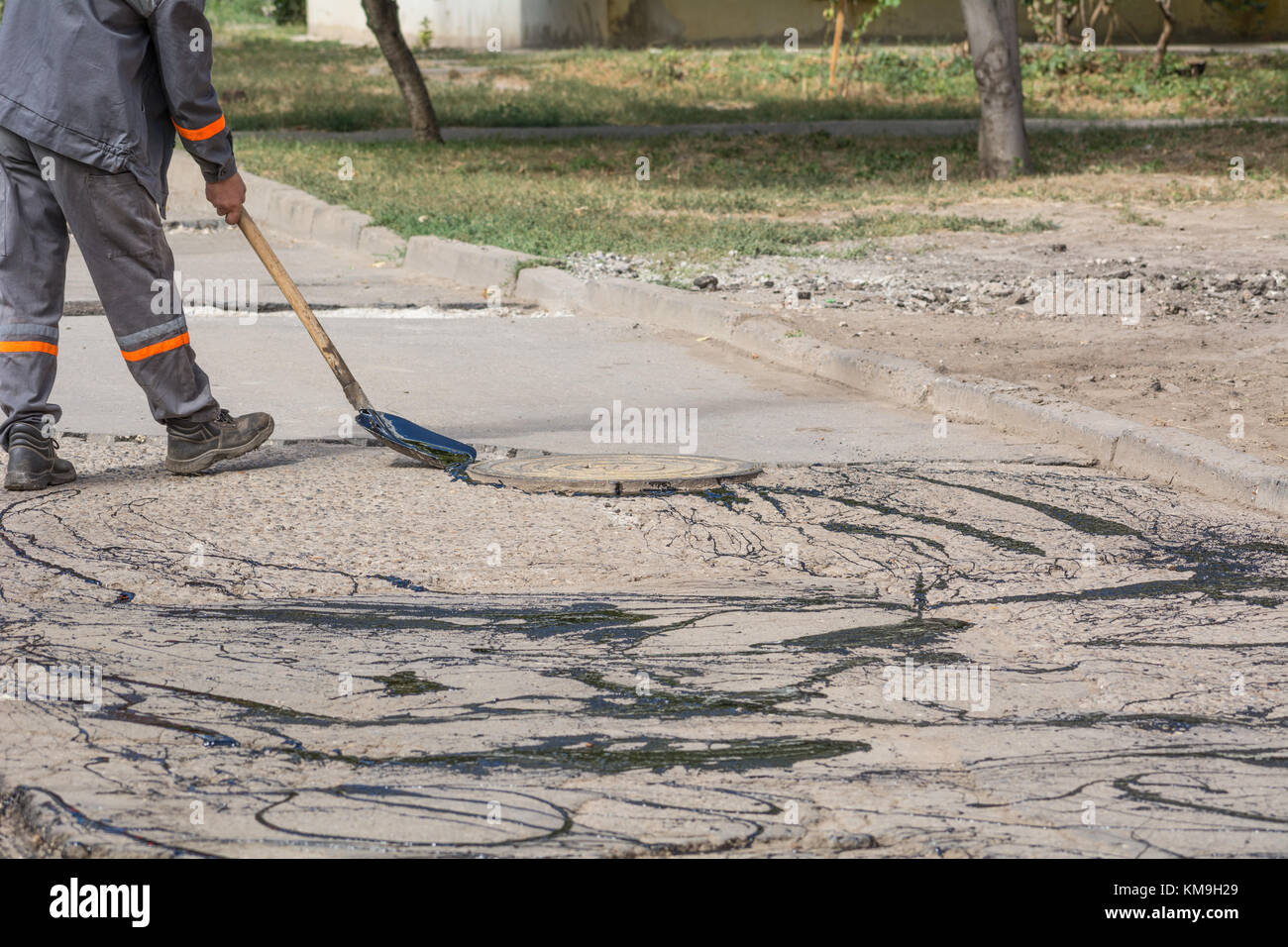 Road repair. Work details, workers pour resin road surface to cover the ...