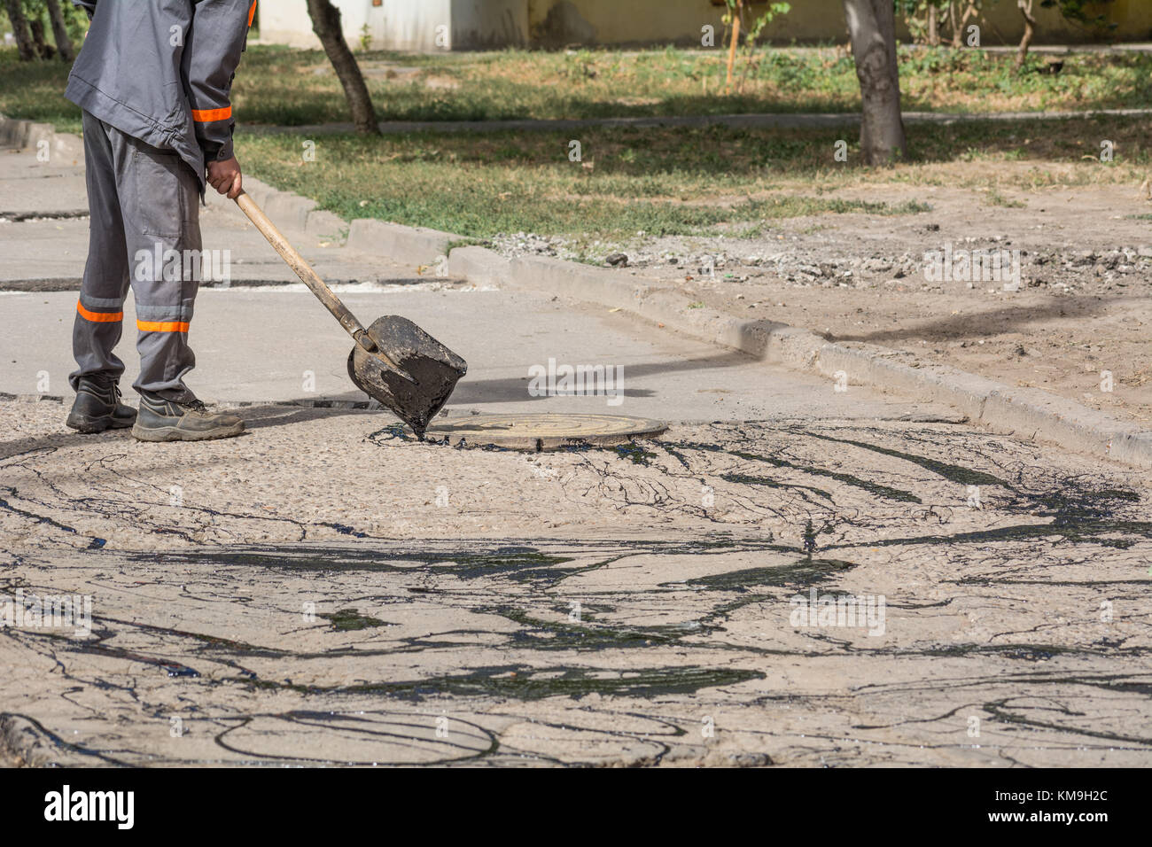 Road repair. Work details, workers pour resin road surface to cover the ...
