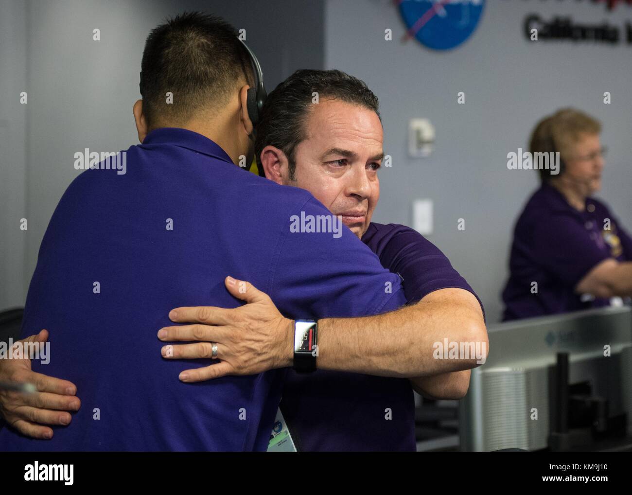 Mission control room scientists embrace after the Cassini spacecraft ...