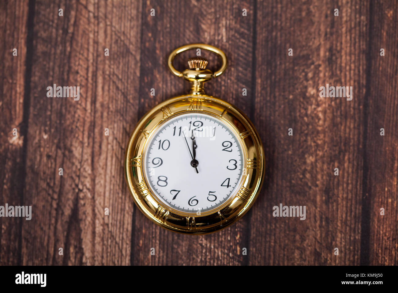 Vintage golden clock showing midnight, on wooden background Stock Photo ...