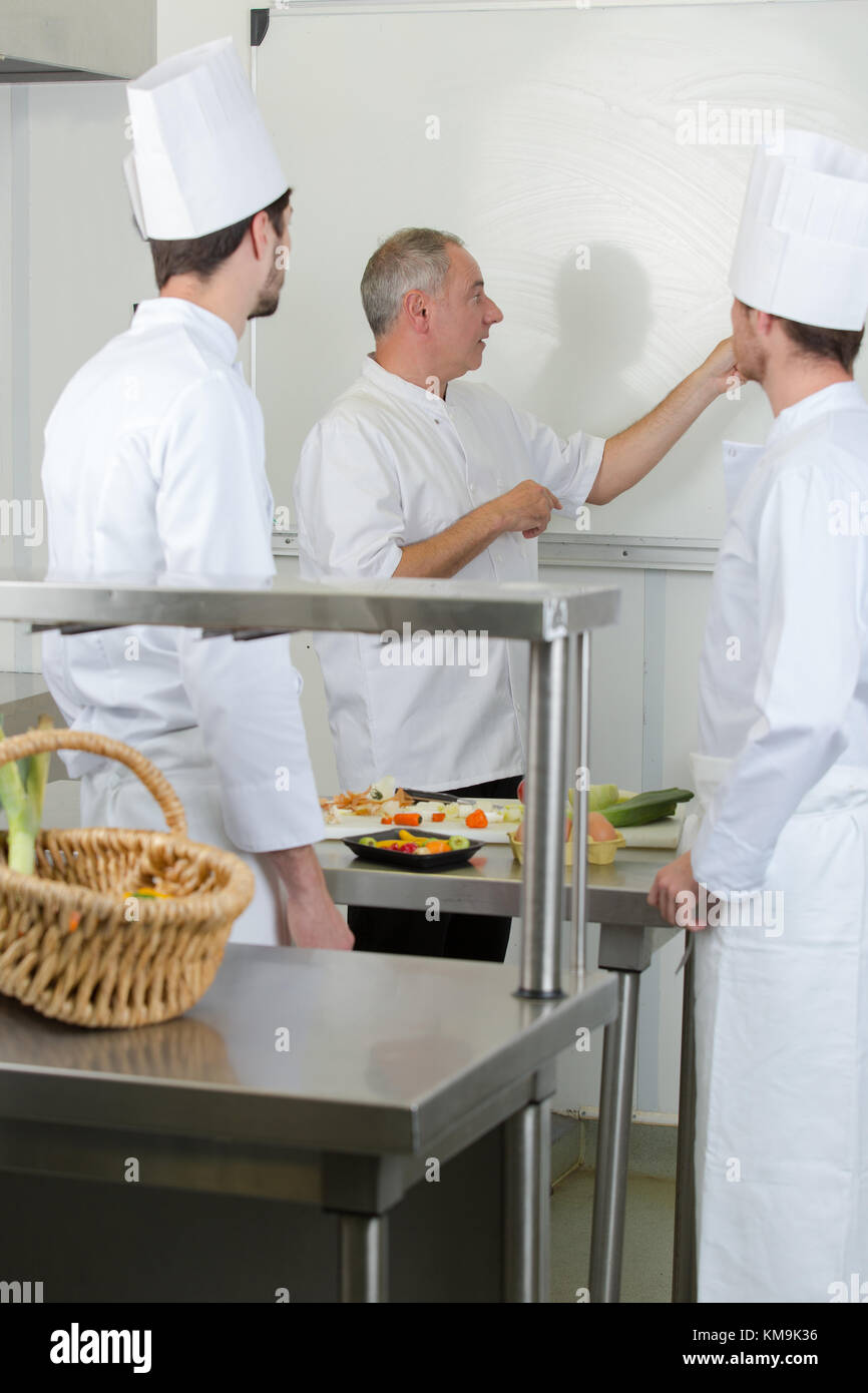 senior chef stood by whiteboard two students listening Stock Photo - Alamy