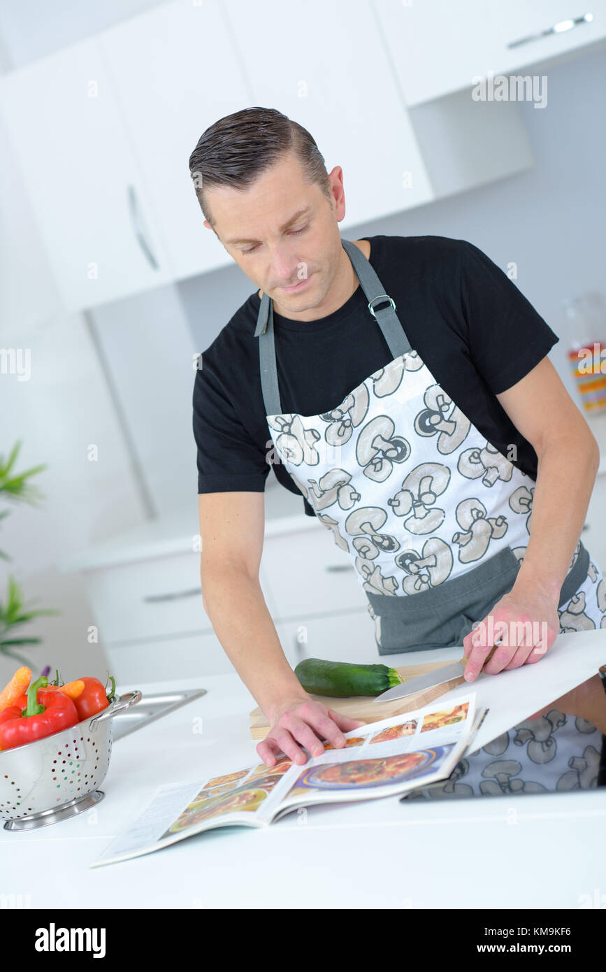man reading the procedures from the recipe book Stock Photo - Alamy