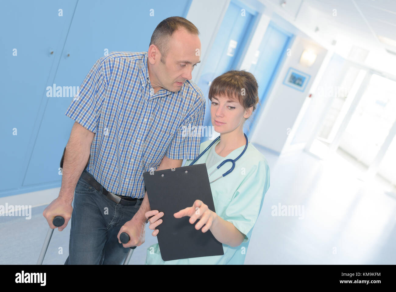 male patient with cast and nurse in hospital corridor Stock Photo - Alamy