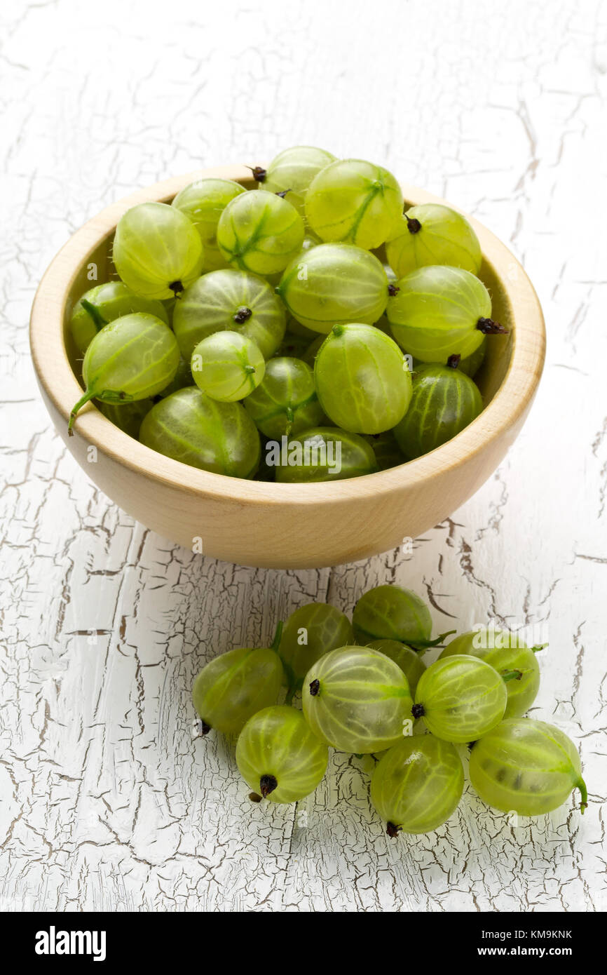 Heap of ripe, fresh harvested green gooseberry fruit in wooden bowl on ...