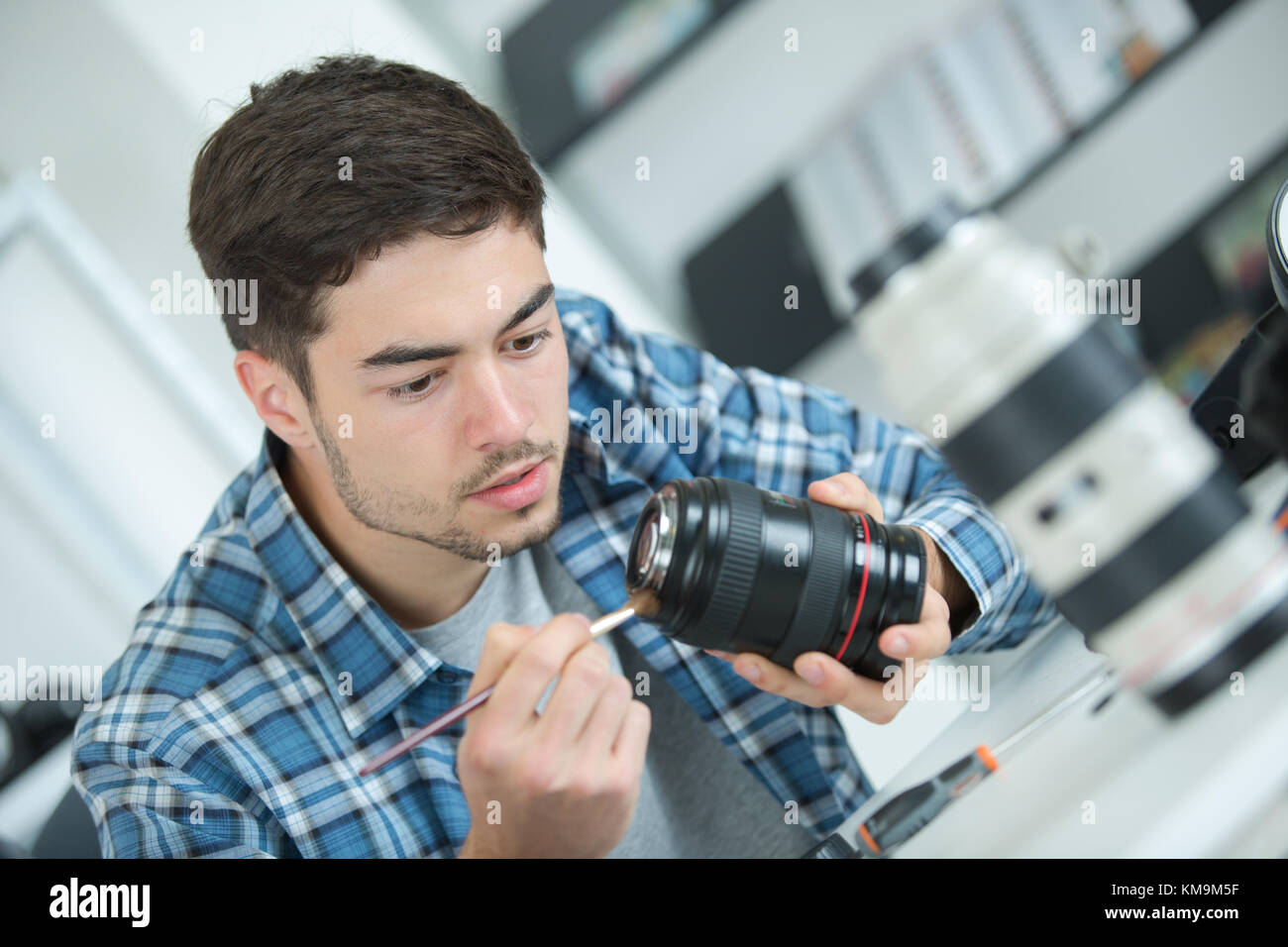 man looking at broken photographic lense Stock Photo - Alamy
