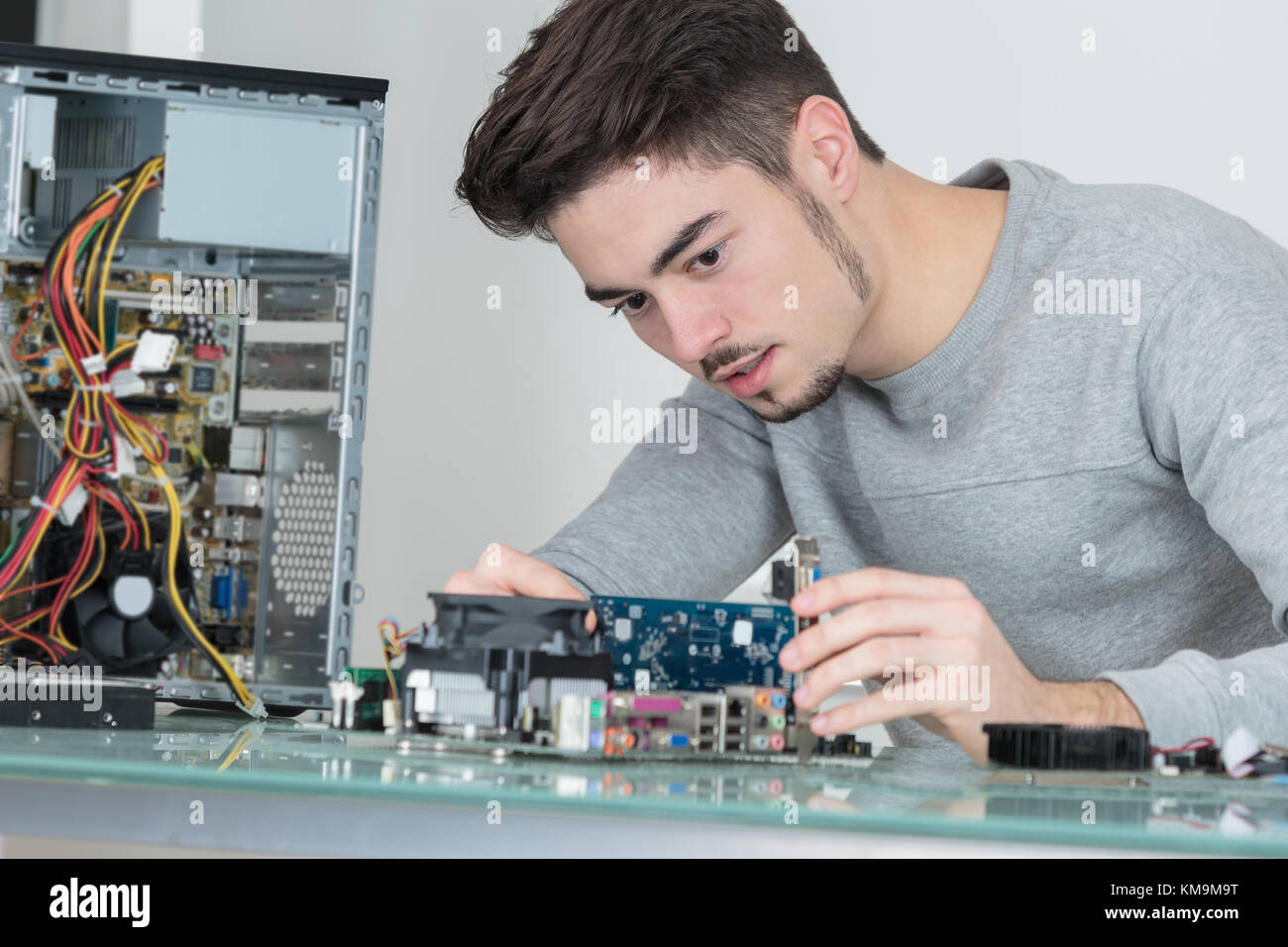 Young man repairing computer Stock Photo - Alamy