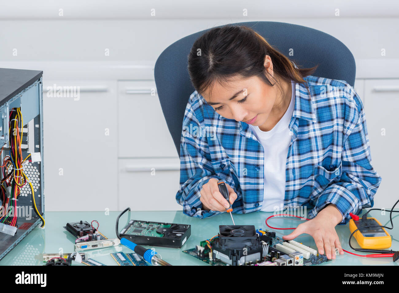 smiling woman fixing computer on a white background Stock Photo - Alamy