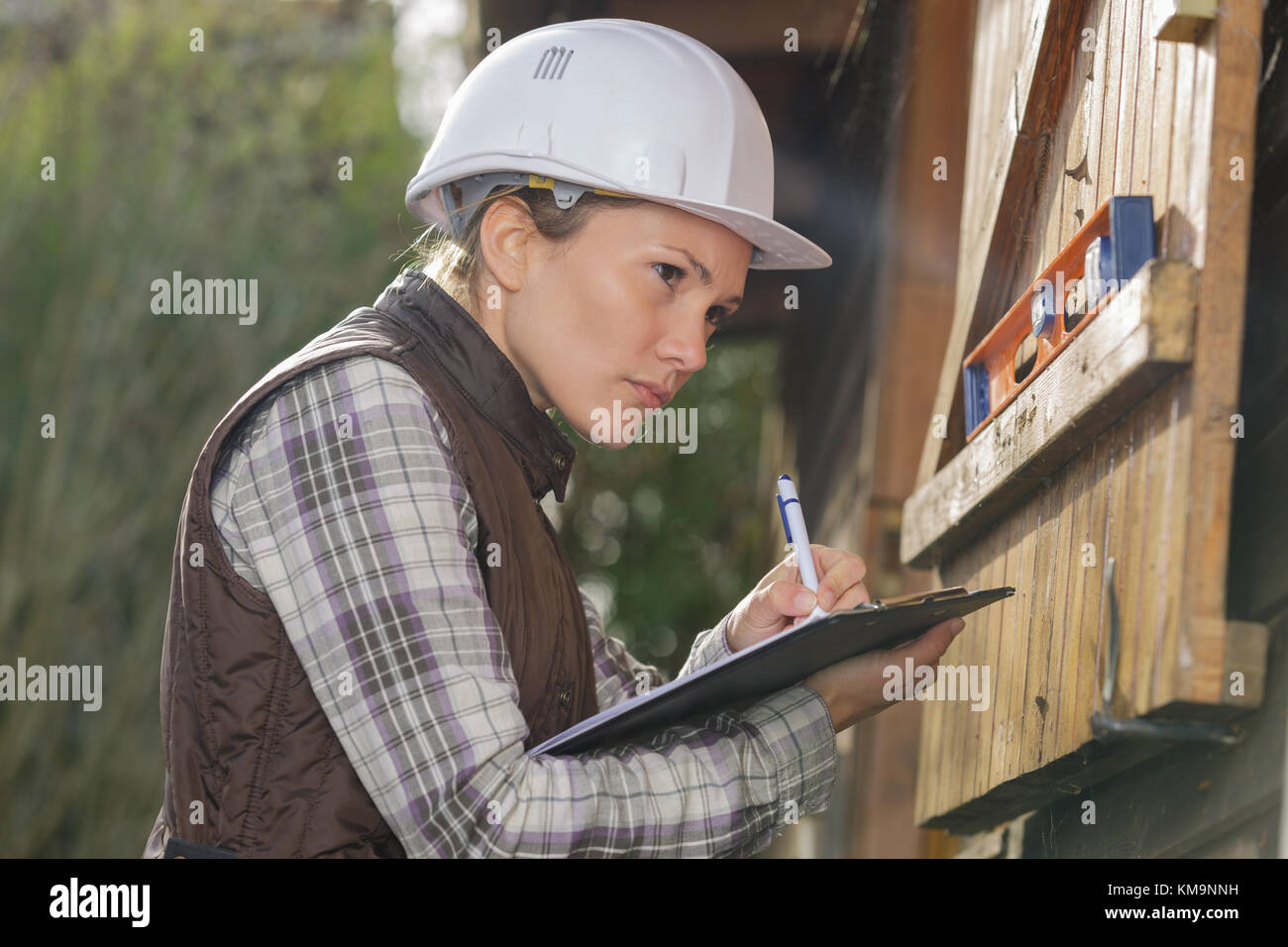 female architect inspecting wooden house Stock Photo - Alamy
